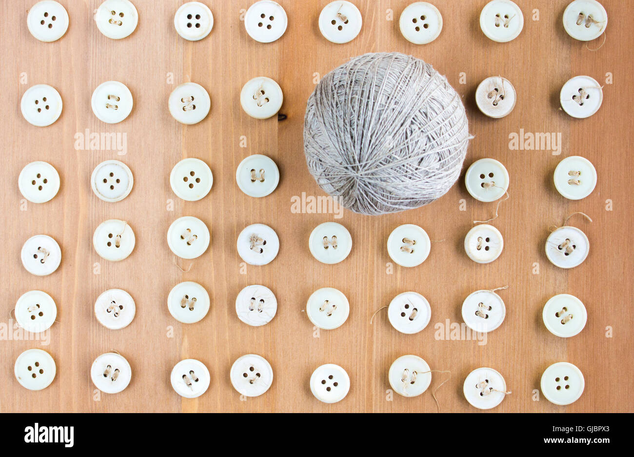 Old sewing buttons and ball of linen threads in the middle as pattern ...