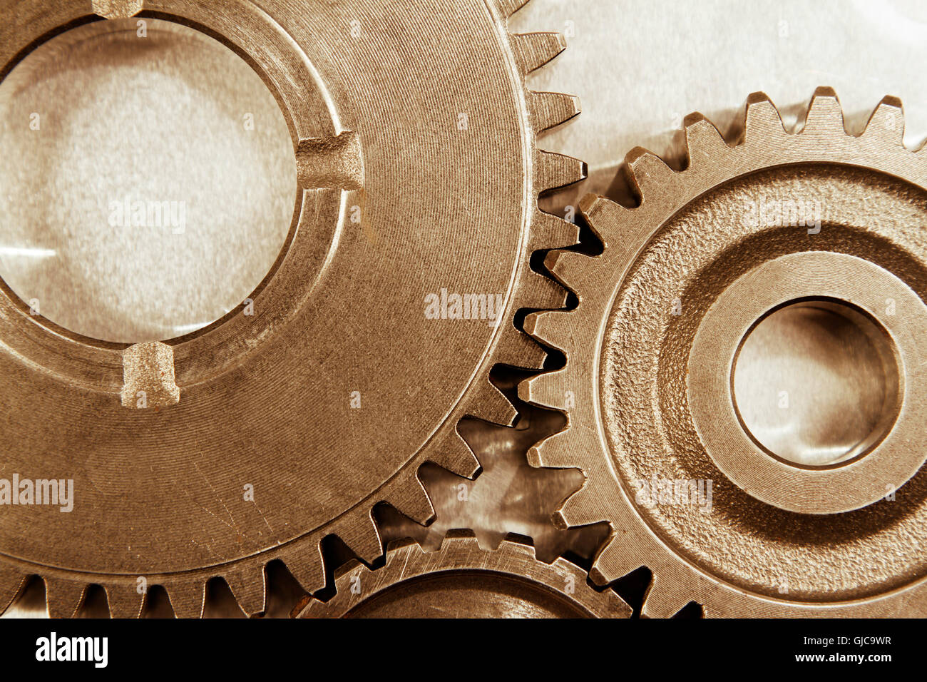 Metal cog gears joining together Stock Photo - Alamy