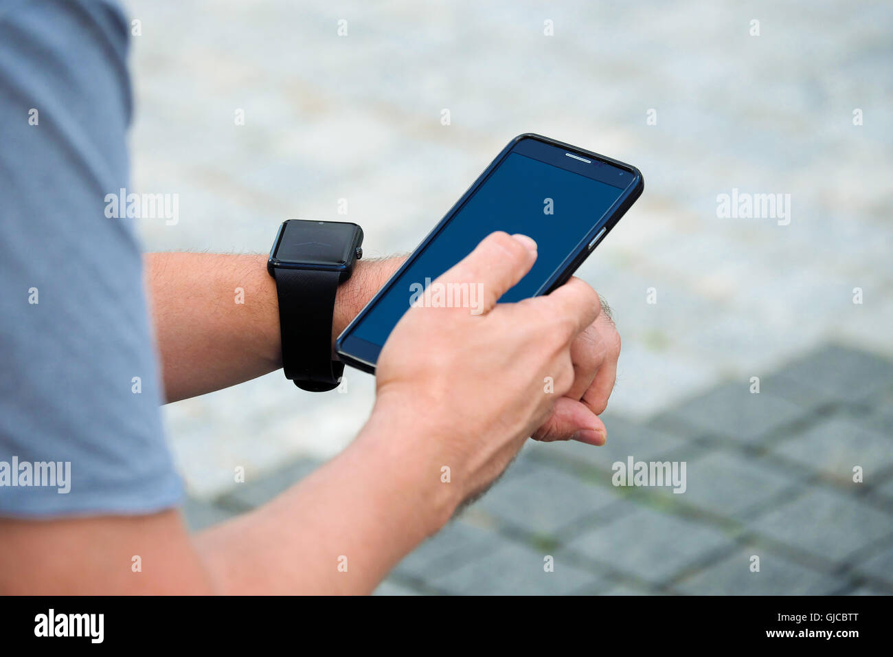 Man checking his smartwatch outdoors. High angle shot. Selective focus ...