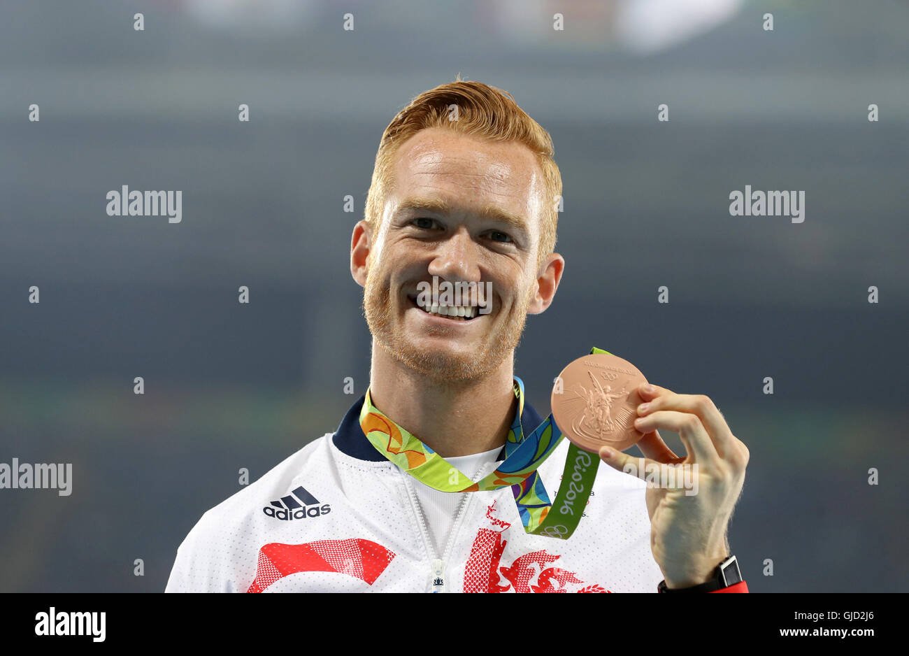Great Britain's Greg Rutherford holds up his bronze medal from the men ...