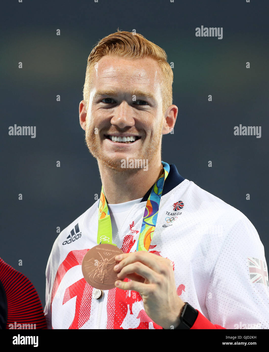 Great Britain's Greg Rutherford holds up his bronze medal from the men ...