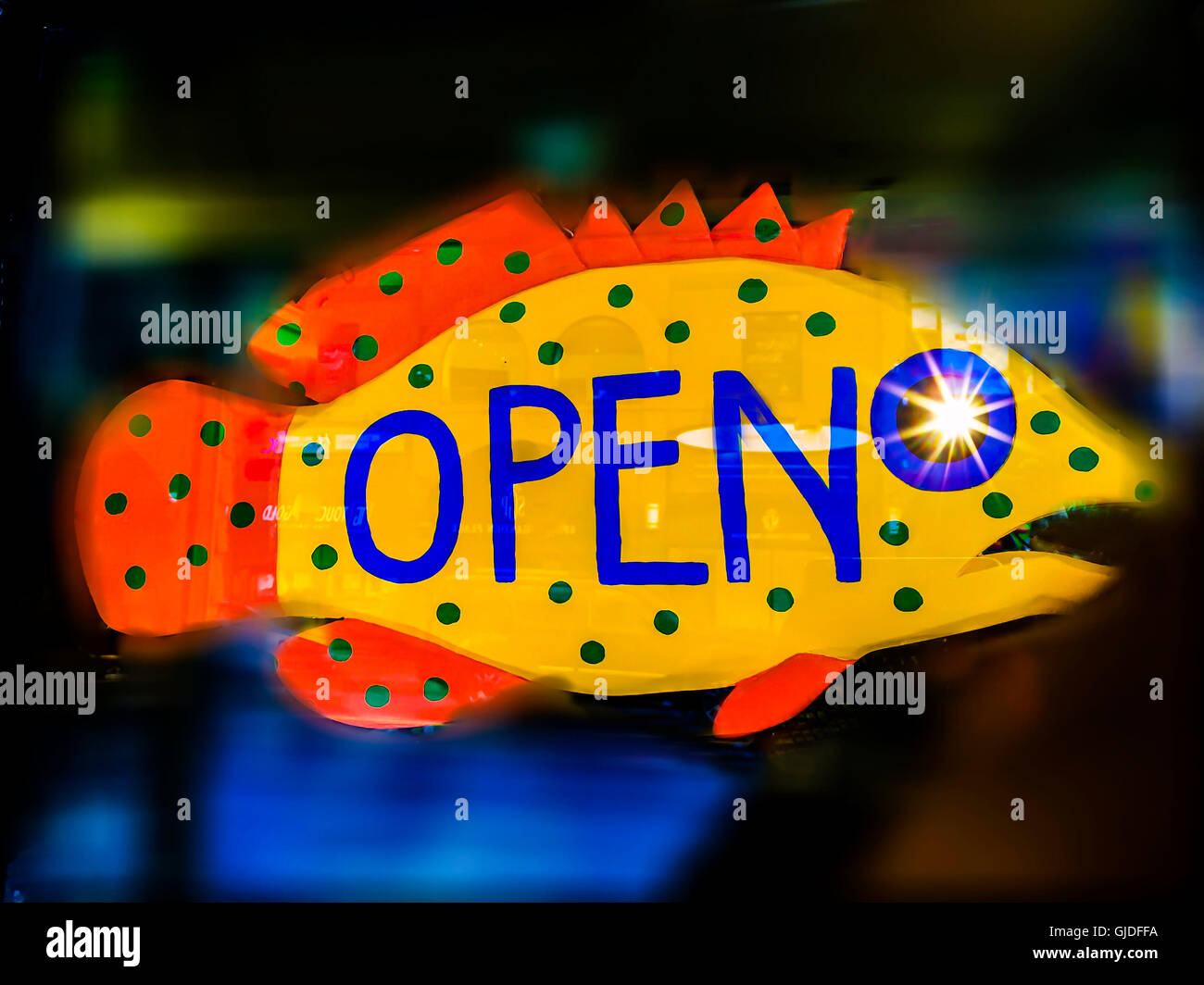 A Colorful hand painted OPEN sign in the shape of a fish on a store ...