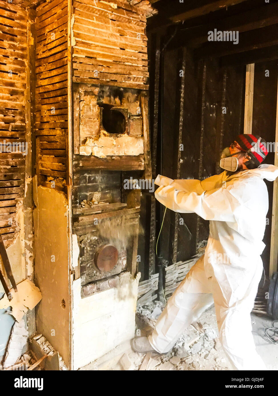 Home renovation. A construction worker, wearing protective clothing and ...