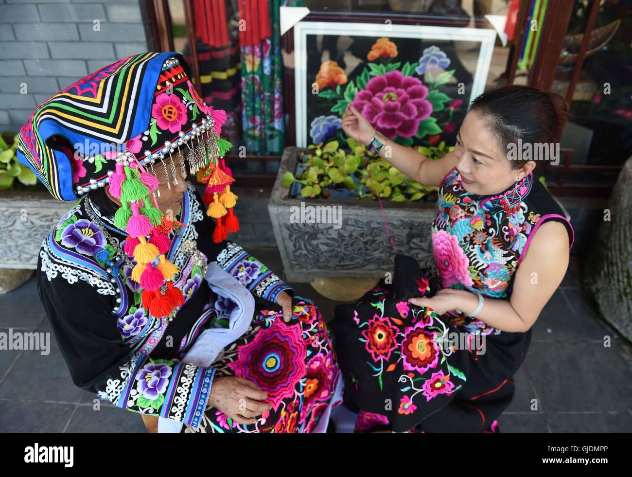 Dayao, China's Yunnan Province. 14th Aug, 2016. Luo Jun (R) weaves an ...