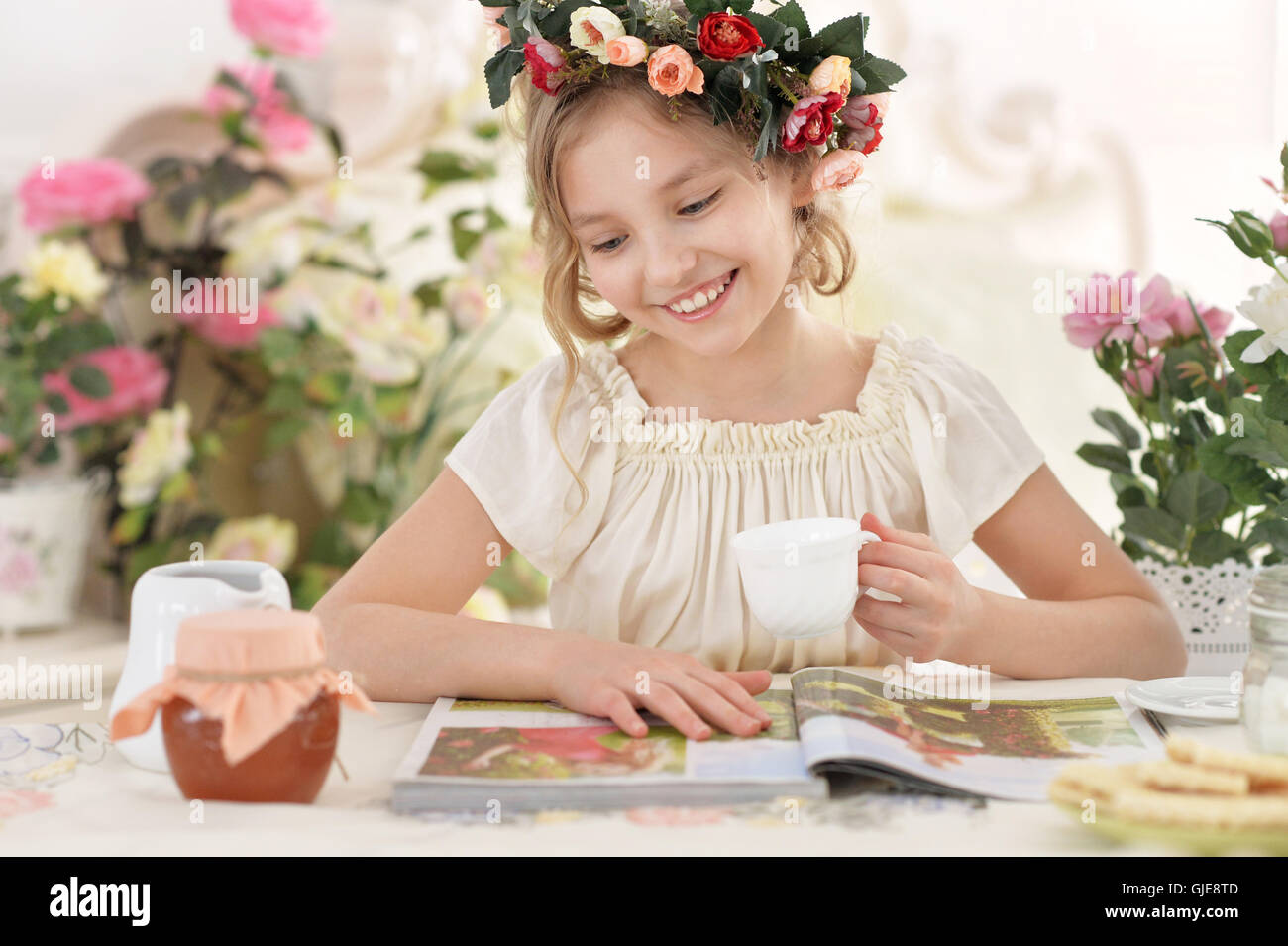 Beautiful little girl reading magazine Stock Photo - Alamy