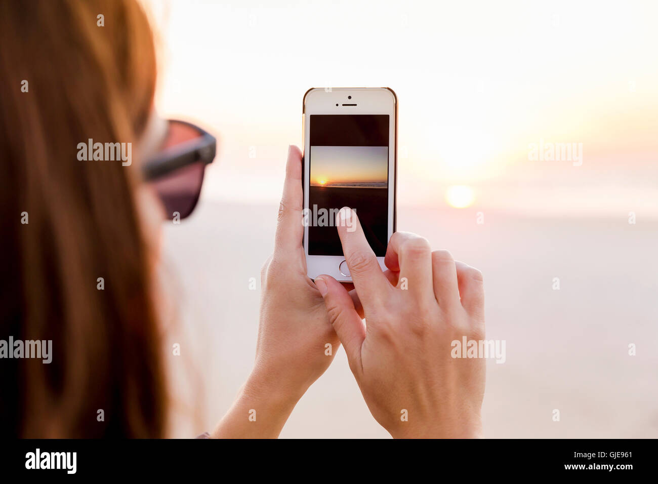 Woman taking photos of the landscape with her smartphone hi-res stock ...