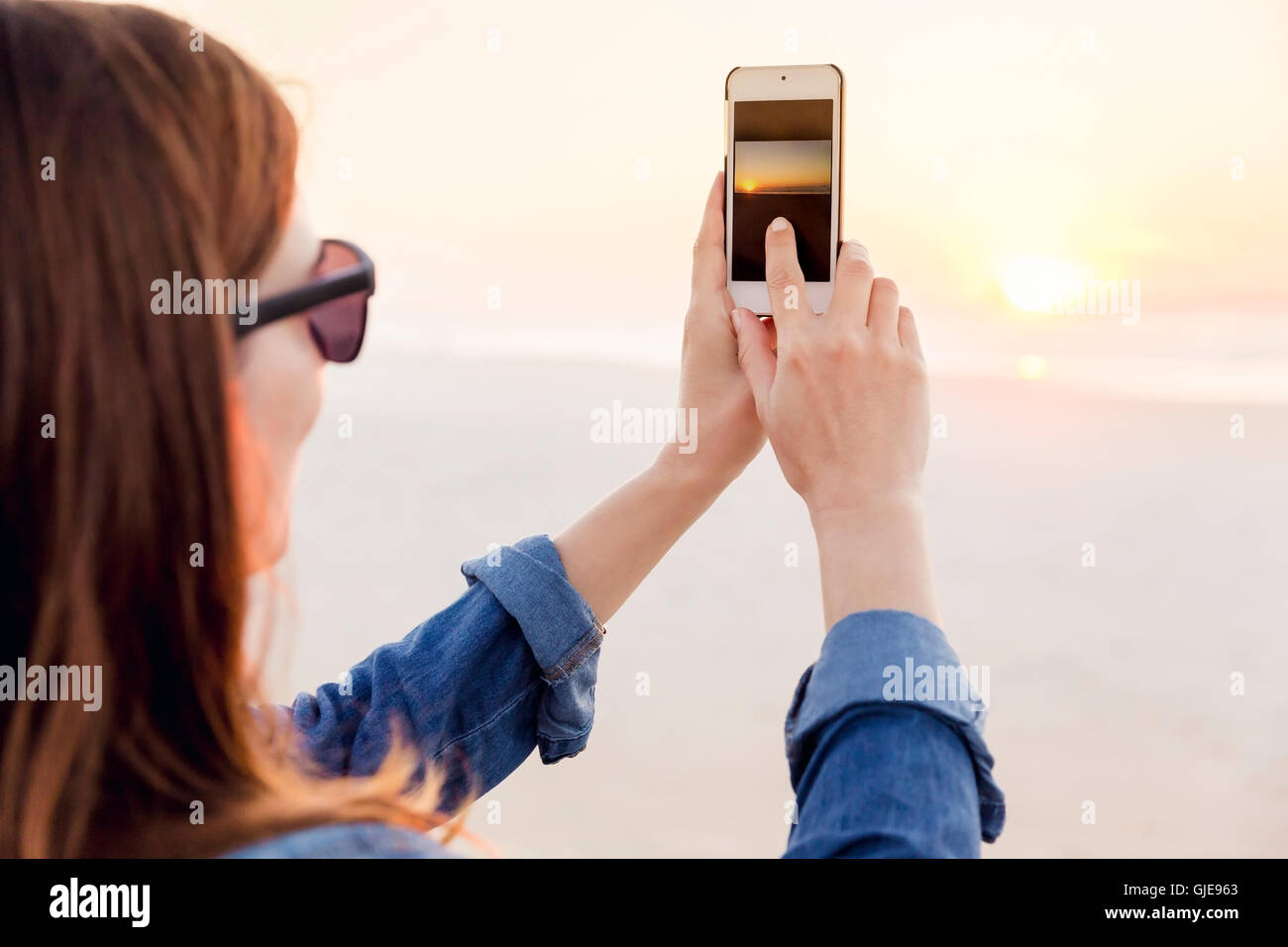 Beautiful woman taking pictures with a cellphone Stock Photo - Alamy