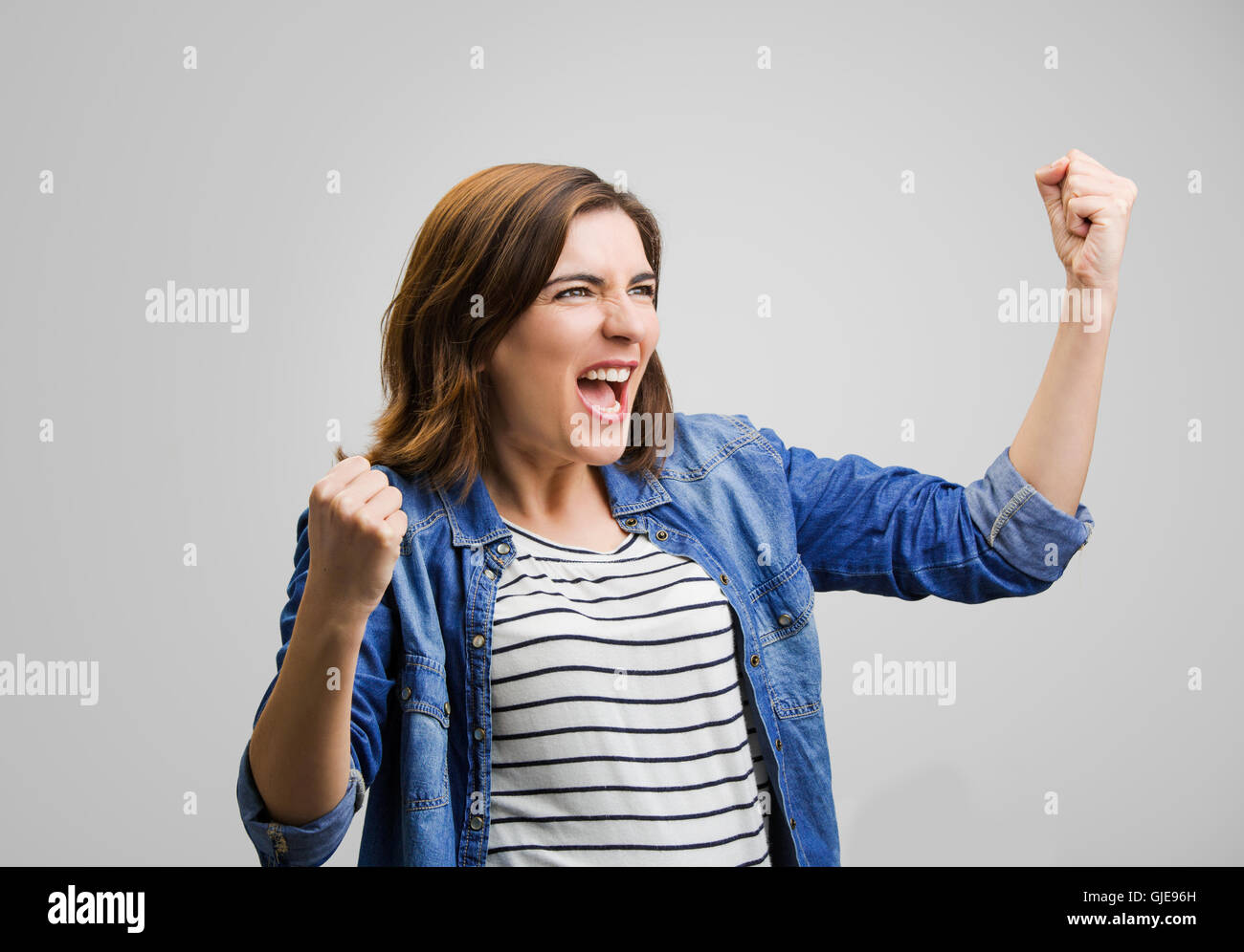 Studio portrait of a successful woman with arms raised Stock Photo - Alamy
