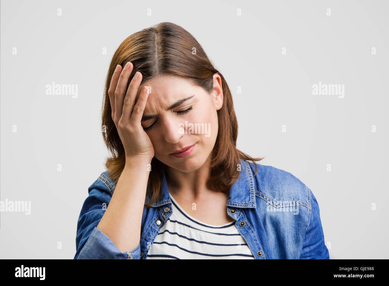 Frustrated woman holding head in hands and expressing pain Stock Photo ...