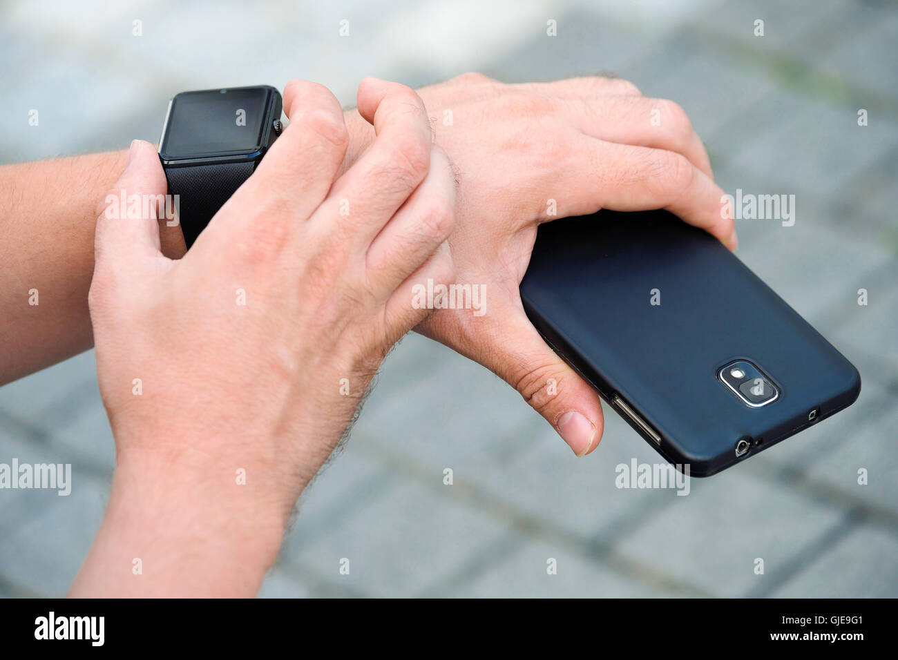 Man checking his smartwatch outdoors. High angle shot. Selective focus ...