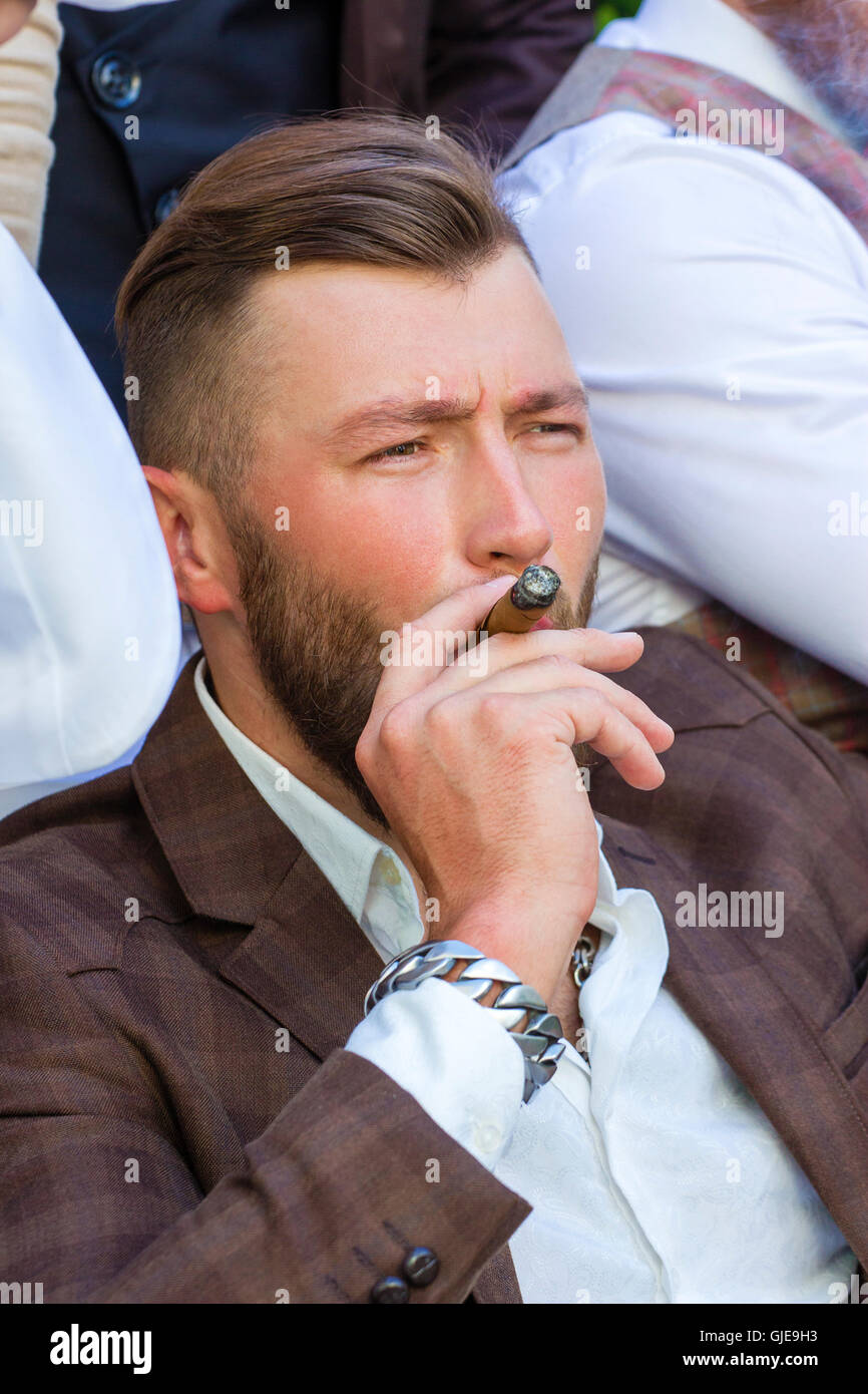 Elegant bearded man smoking a cigar outdoors Stock Photo - Alamy