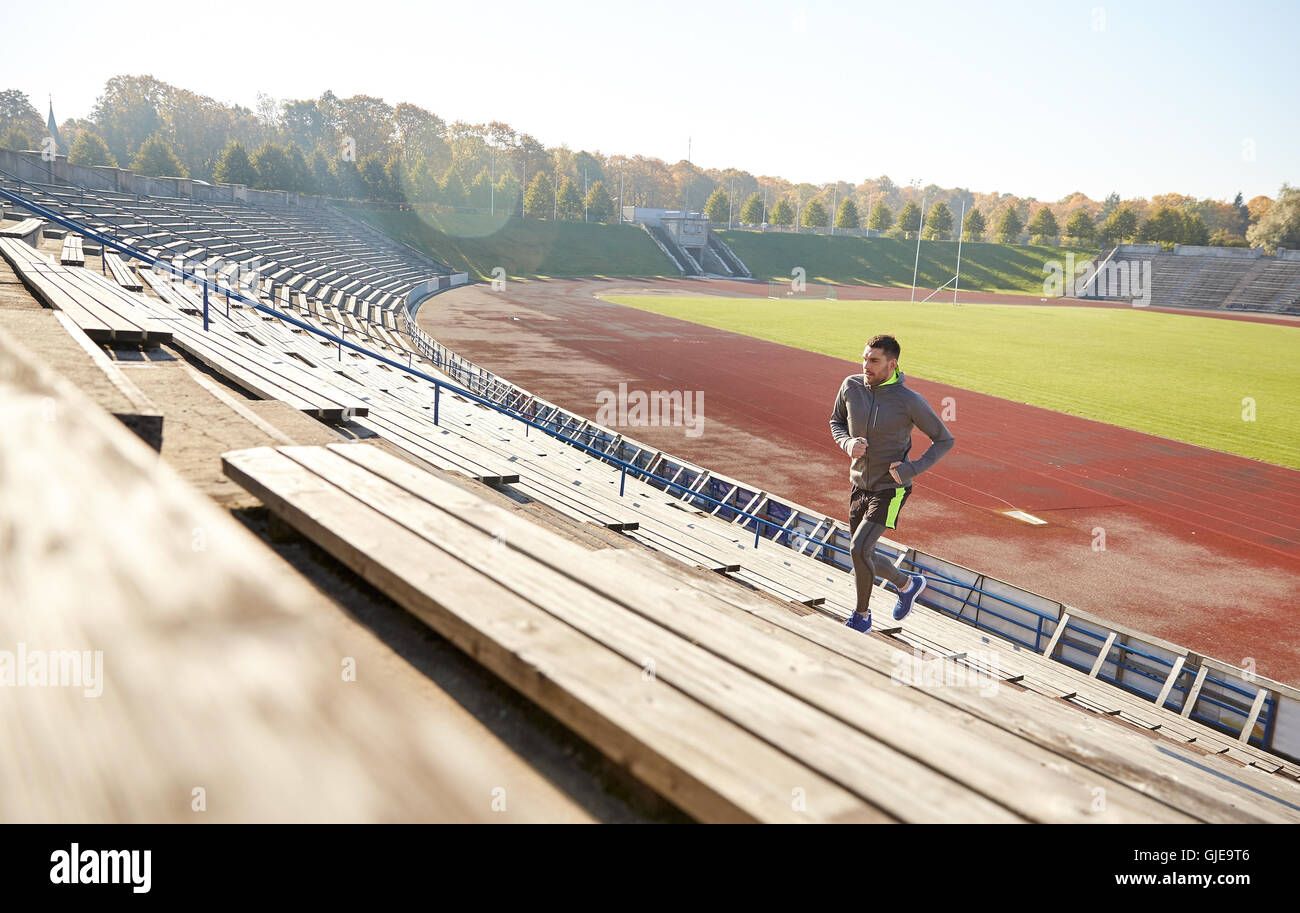 happy young man running upstairs on stadium Stock Photo - Alamy
