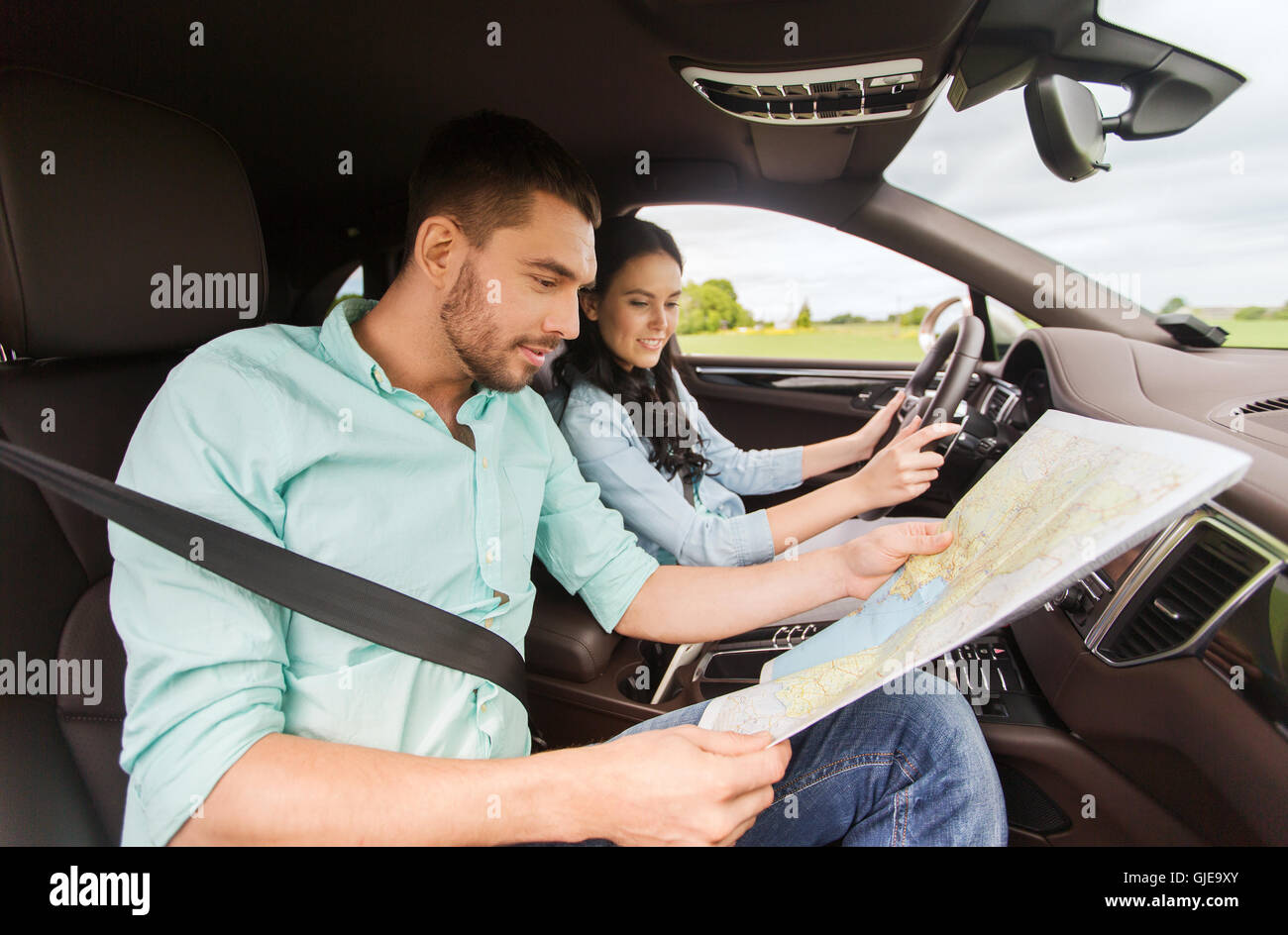 happy man and woman with road map driving in car Stock Photo - Alamy