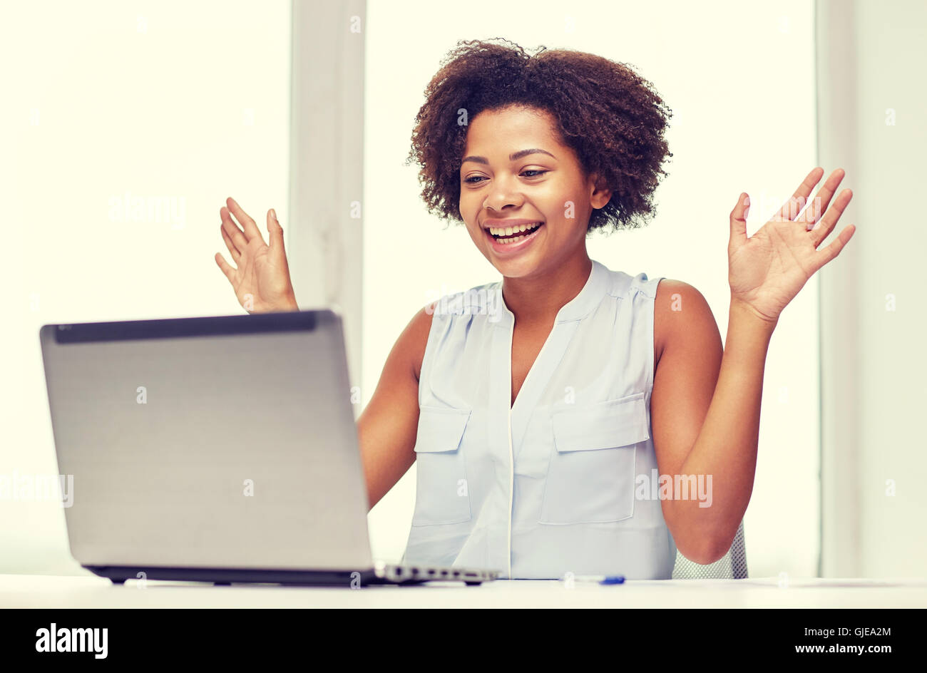 happy african woman with laptop at office Stock Photo - Alamy