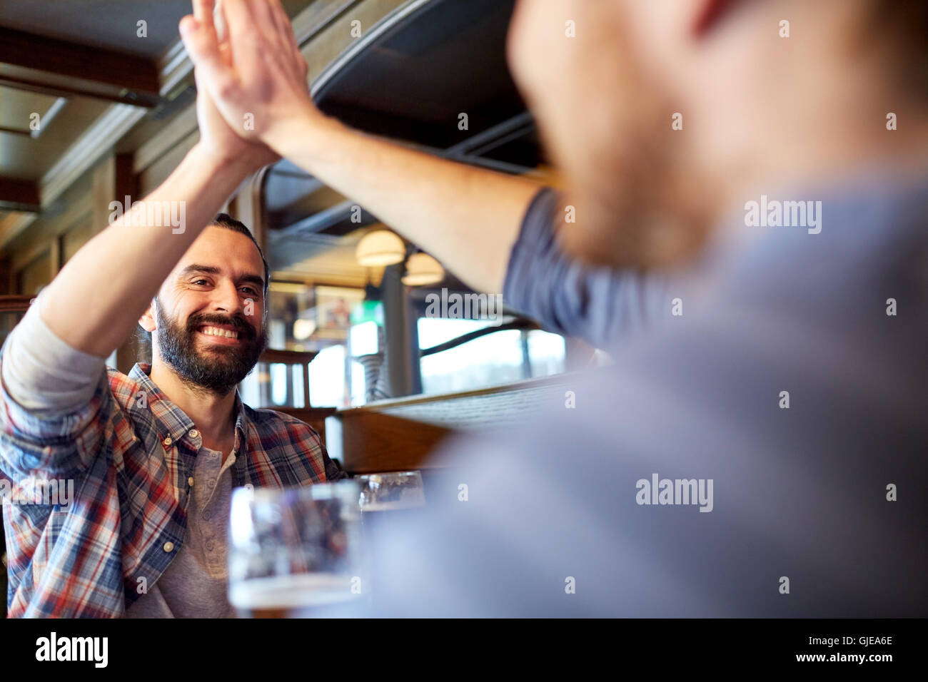 happy male friends making high five at bar or pub Stock Photo - Alamy