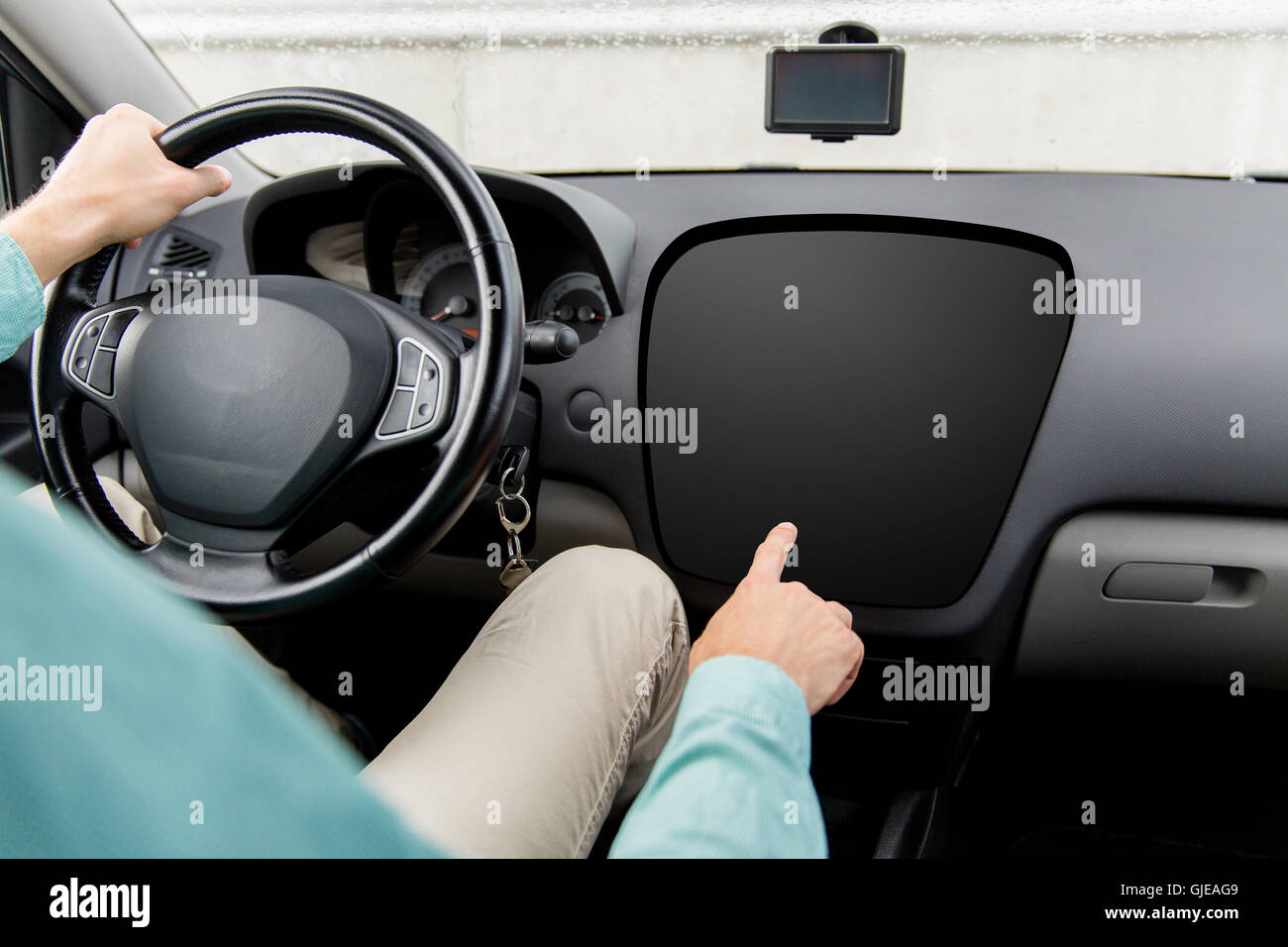 man driving car and pointing to on-board computer Stock Photo - Alamy