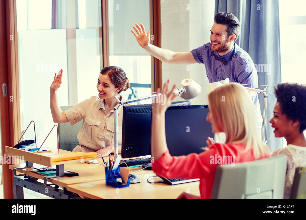 Creative business team waving hi-res stock photography and images - Alamy
