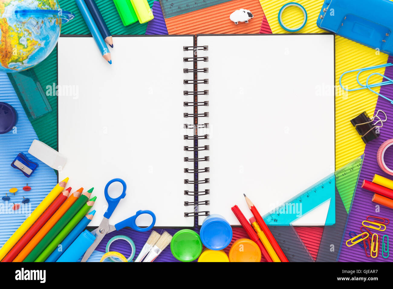 Colorful composition of school supplies: crayons, markers, globe ...