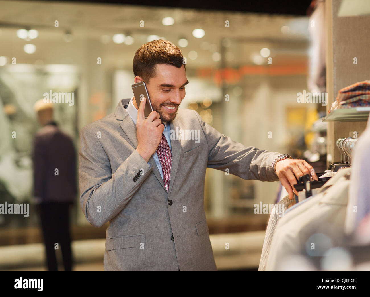 happy man calling on smartphone at clothing store Stock Photo - Alamy