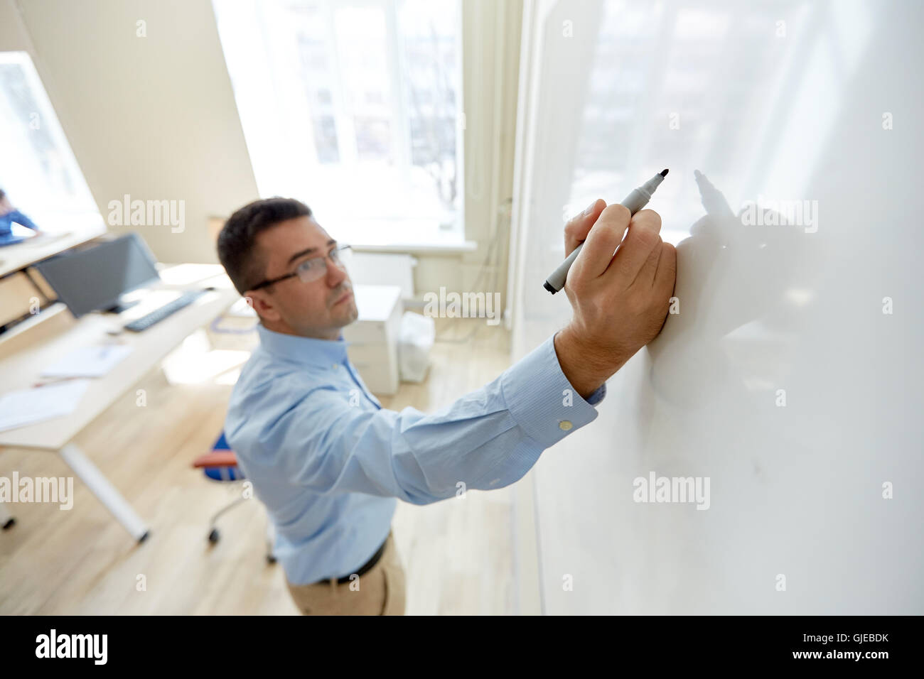 teacher writing on school white board Stock Photo - Alamy