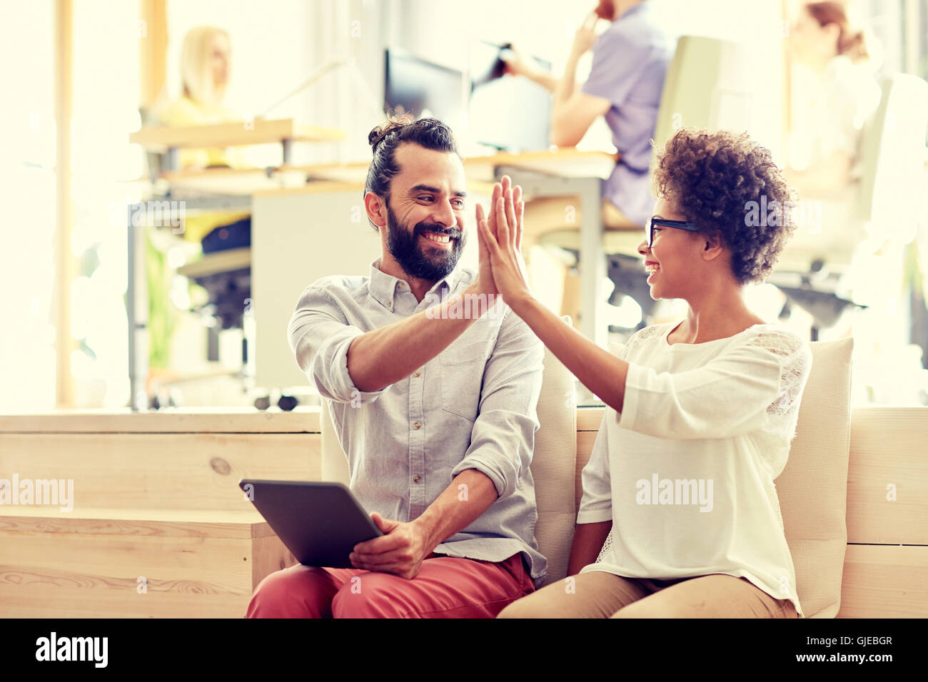 office workers with tablet pc making high five Stock Photo - Alamy