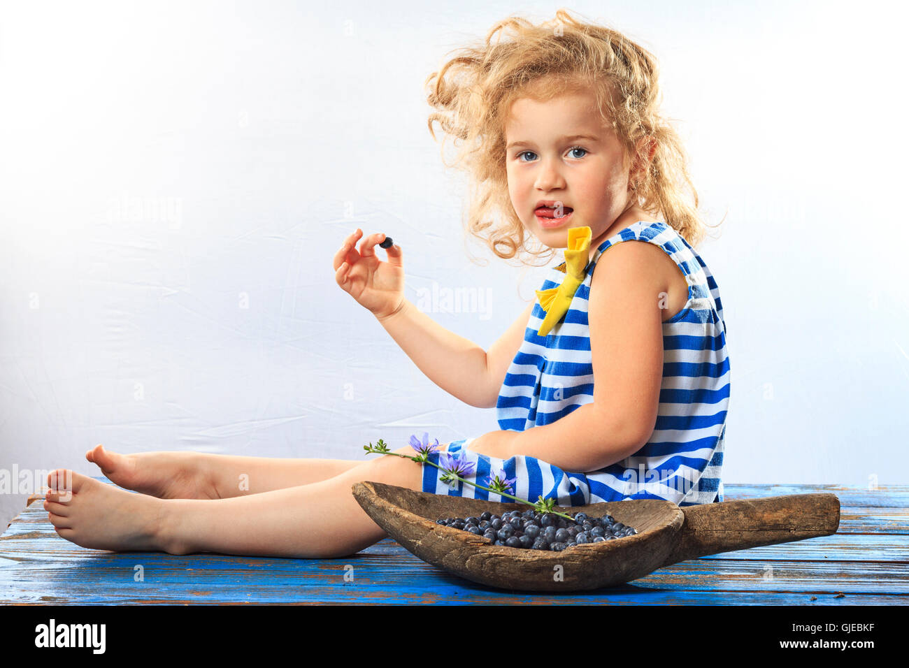 little girl holds a berry blueberries in hand Stock Photo - Alamy