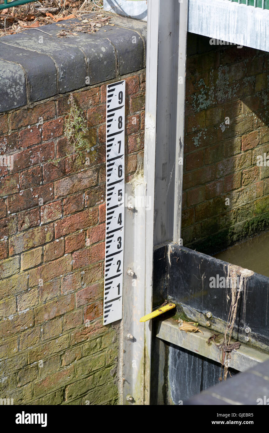 Water depth gauge on downflow side of mechanical weir on river Stock ...