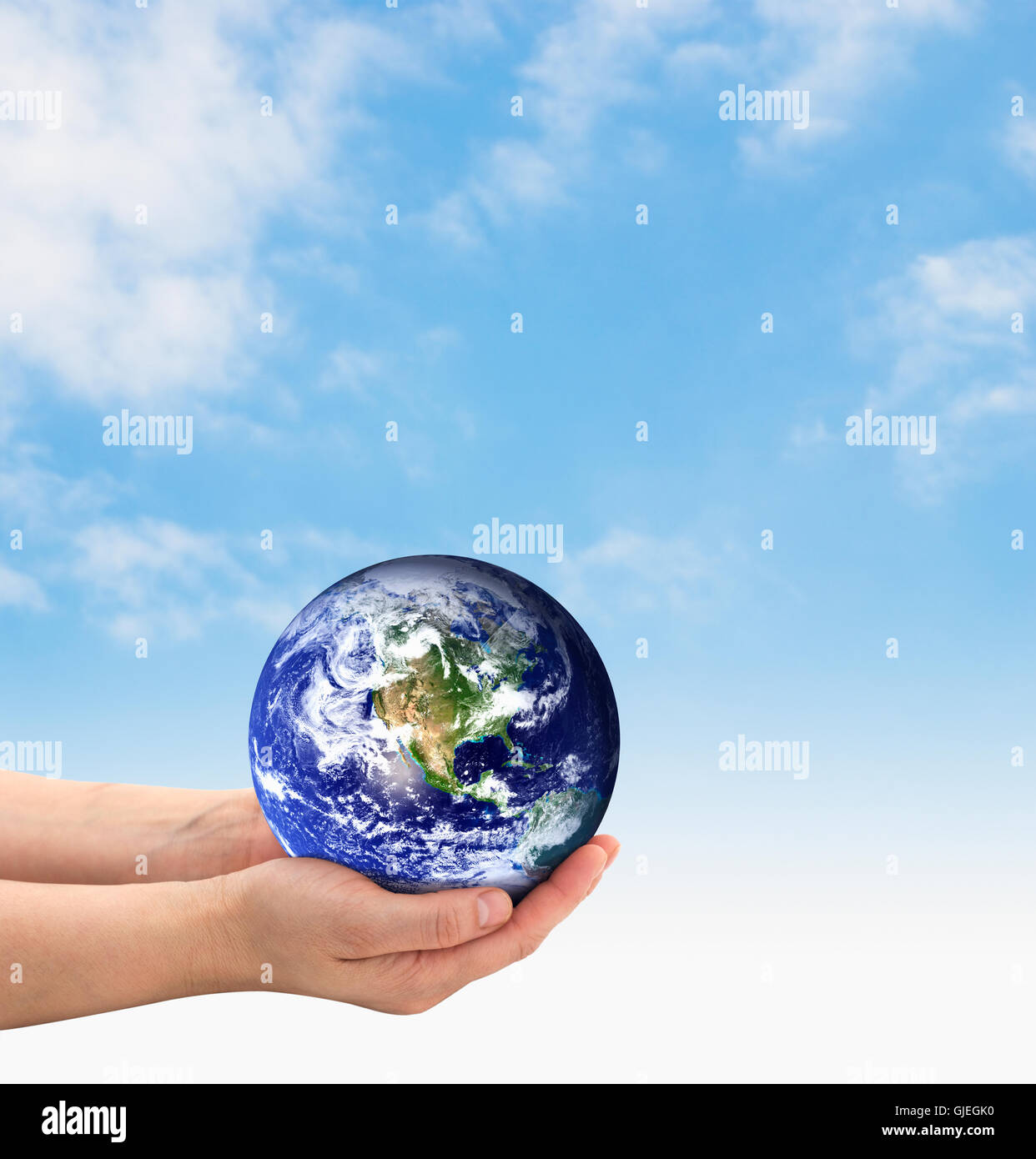 Hands holding earth on a blue sky. The planet earth image provided by ...