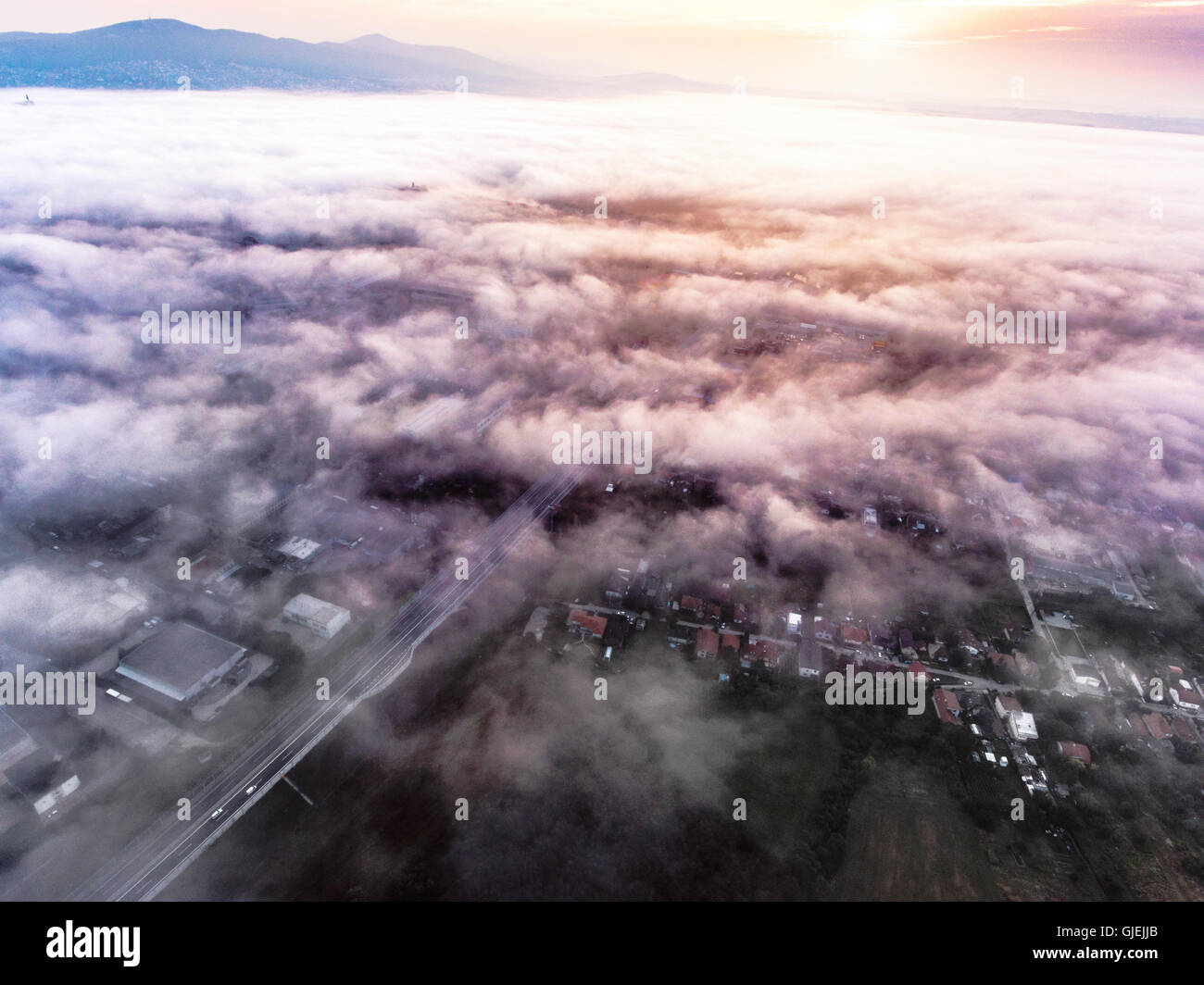 Aerial view of morning town covered by mist, sunrise Stock Photo - Alamy