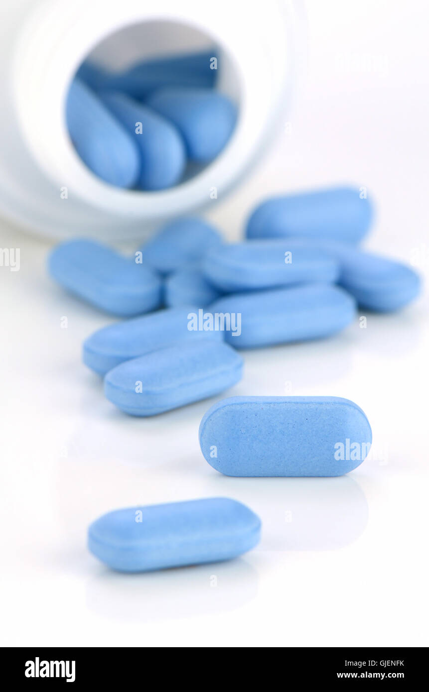 Blue caplets on white background Stock Photo - Alamy