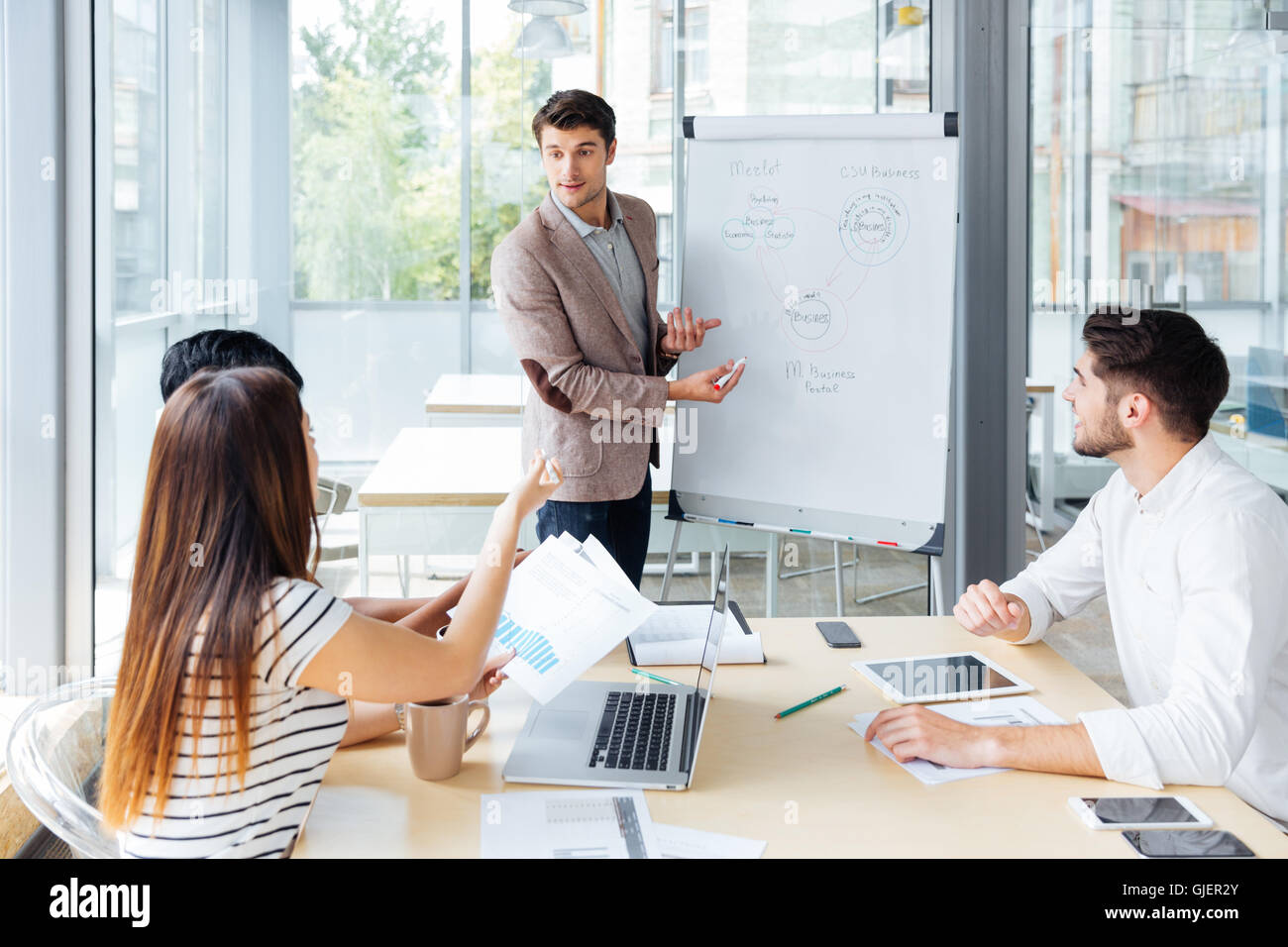 Confident handsome young businessman giving presentation using ...