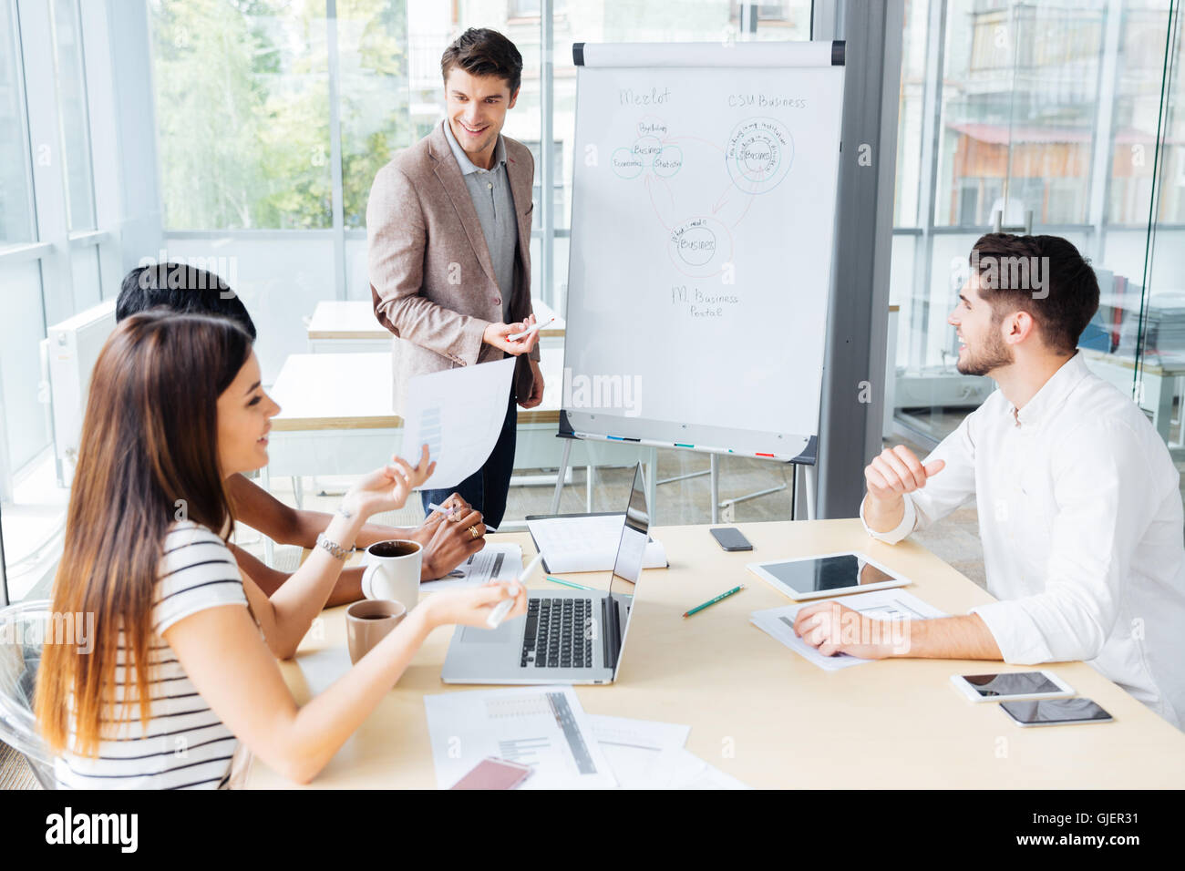 Happy attractive young businessman making presentation for business ...