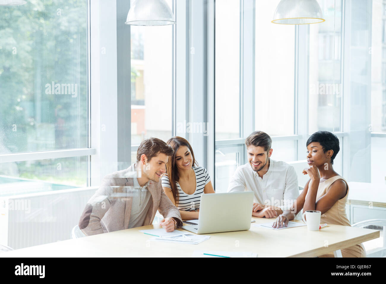 Happy successful young business team working with laptop together in ...