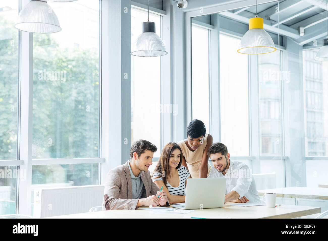 Multiethnic group of young business people creating presentation and ...