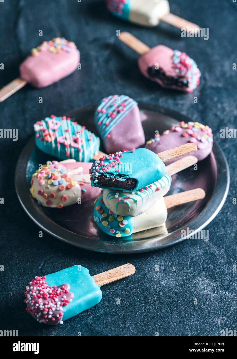 Sweet cake pops with ice cream shape in the plate on dark background ...