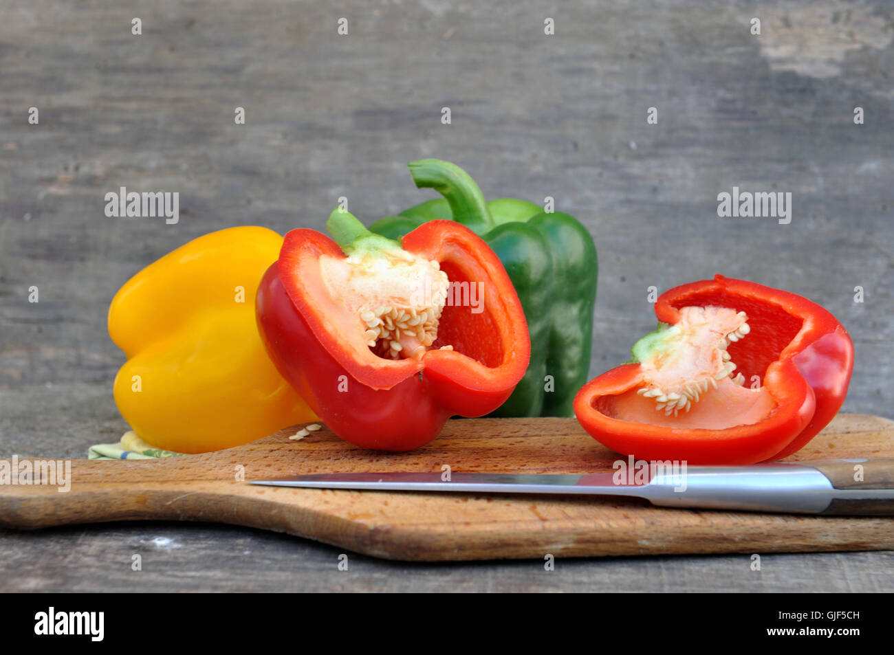 red pepper cut in half with others on board with knife Stock Photo - Alamy