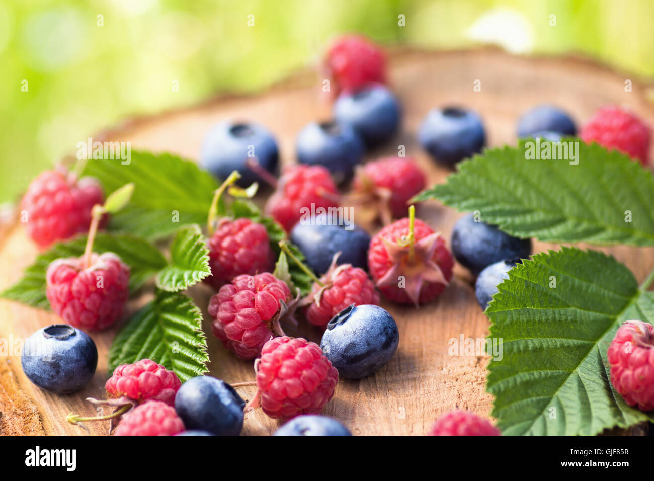 Blueberry and raspberry on wooden surface Stock Photo - Alamy