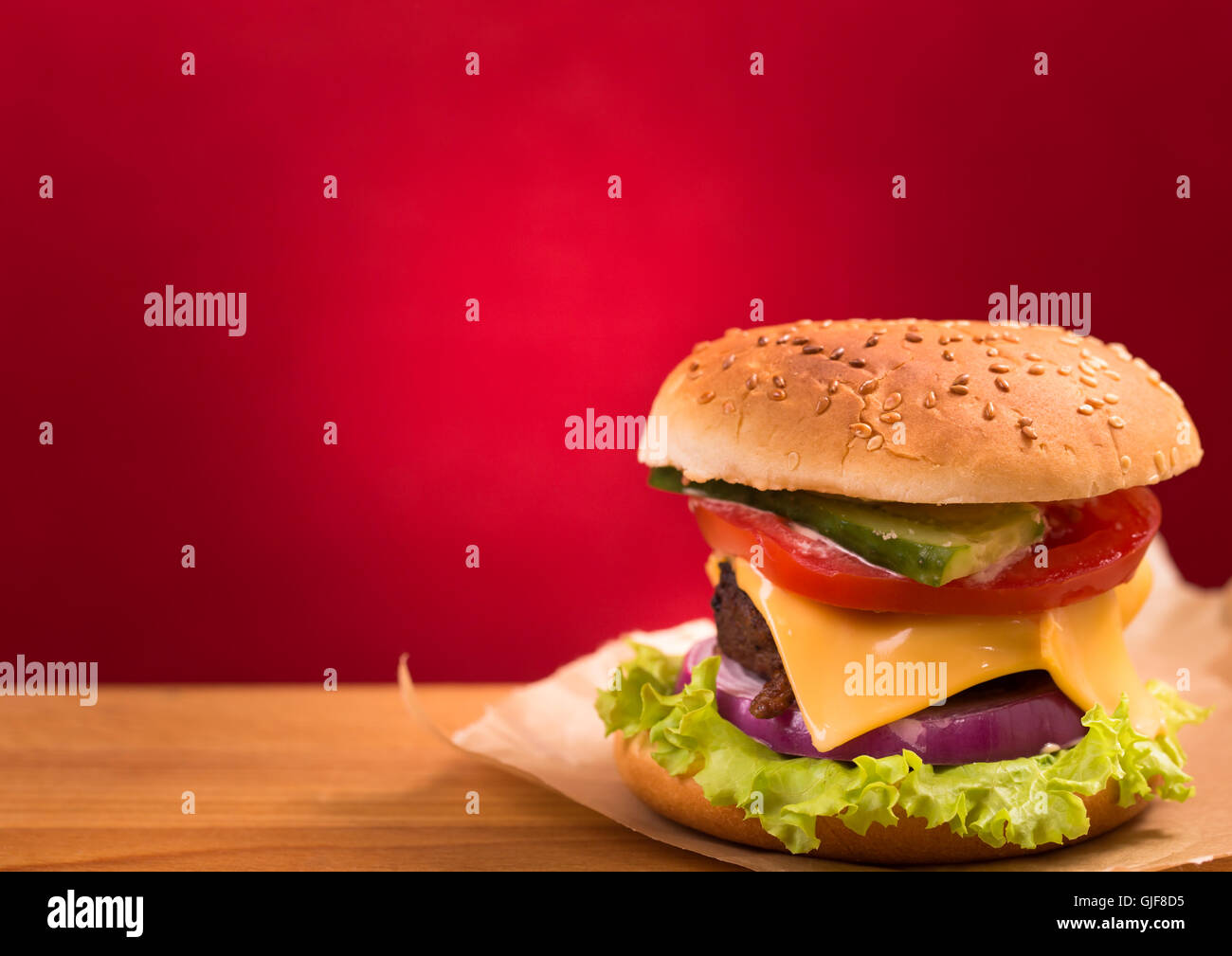 Cheeseburger closeup on red background Stock Photo - Alamy