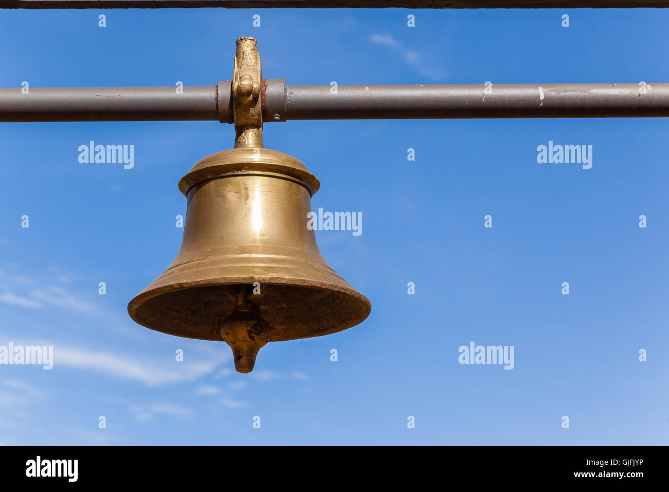 Brass bell hanging ringing instrument closeup against blue sky Stock ...