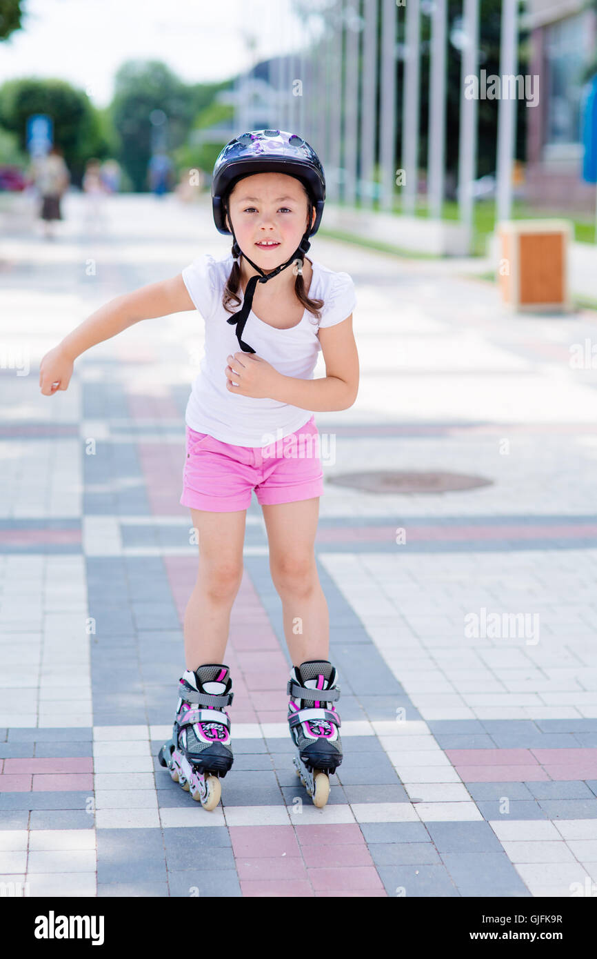Little girl rides on roller skates at park Stock Photo - Alamy