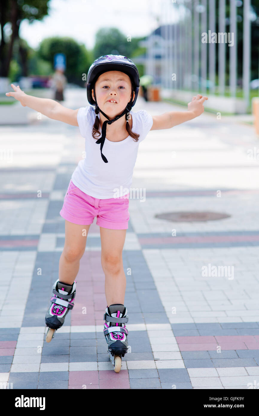 Little girl rides on roller skates at park Stock Photo - Alamy