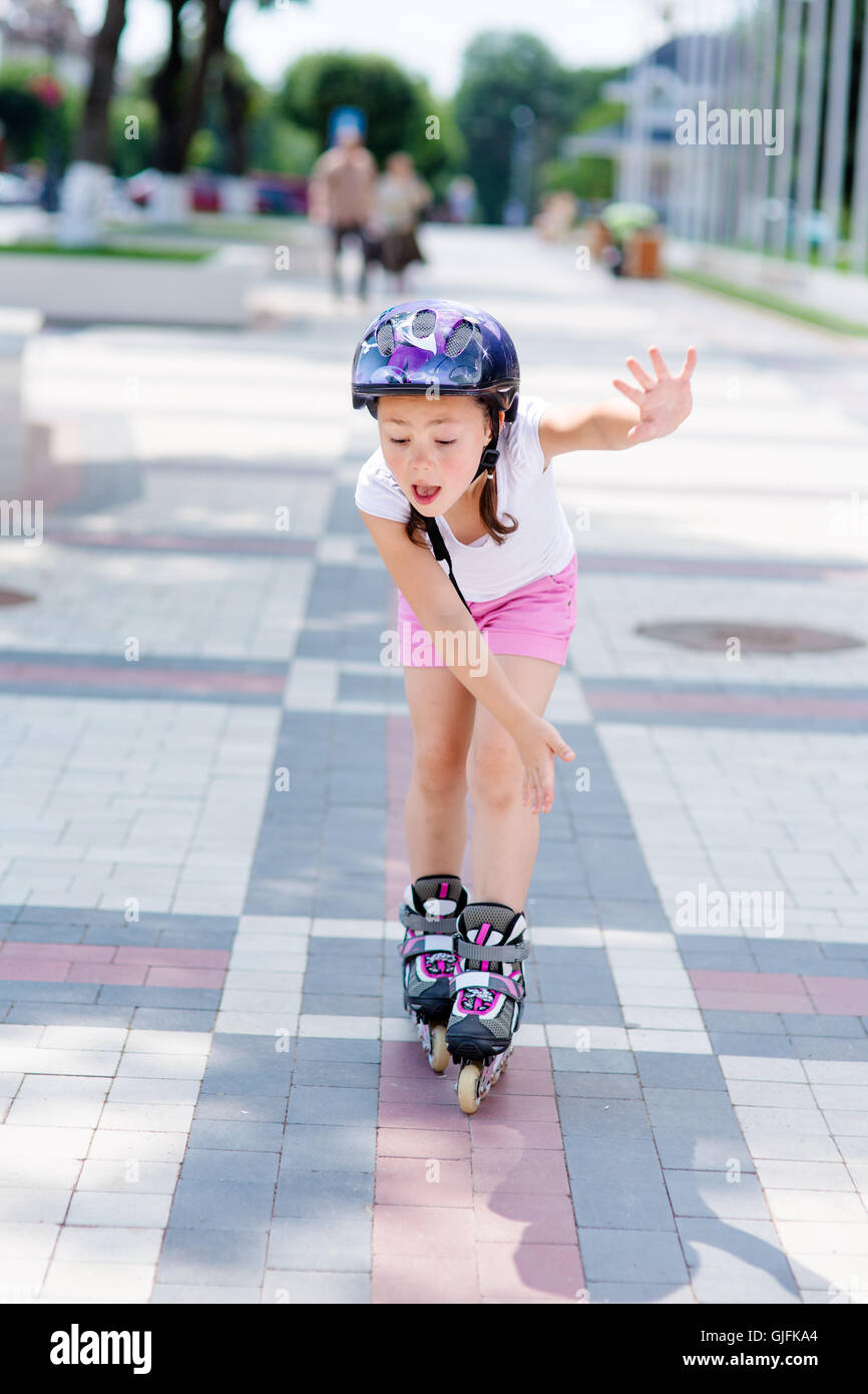 Little girl rides on roller skates at park Stock Photo - Alamy