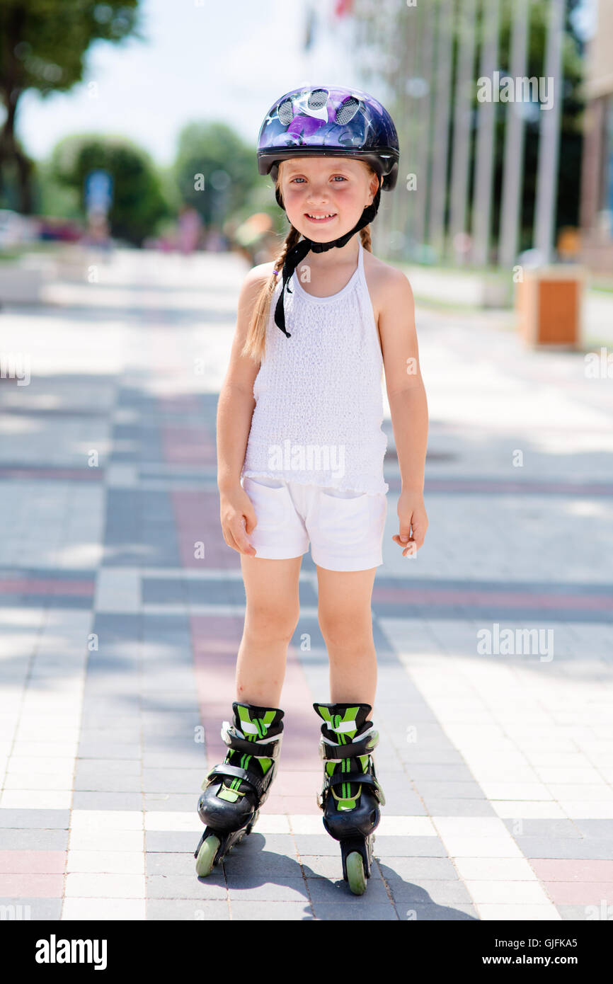 Little girl rides on roller skates at park Stock Photo - Alamy