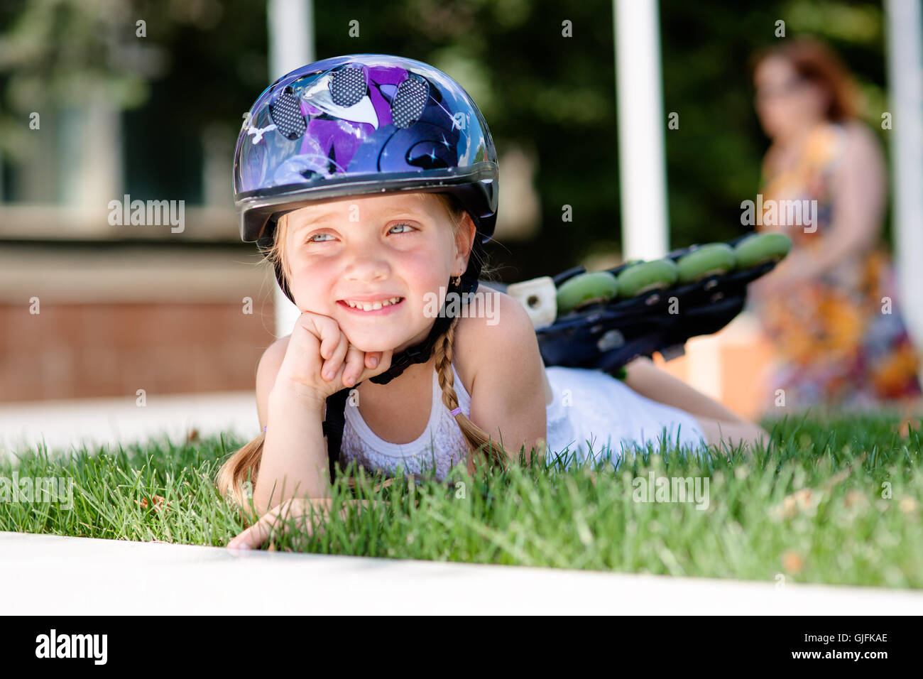 Little girl with roller skates at park laying on grass Stock Photo - Alamy