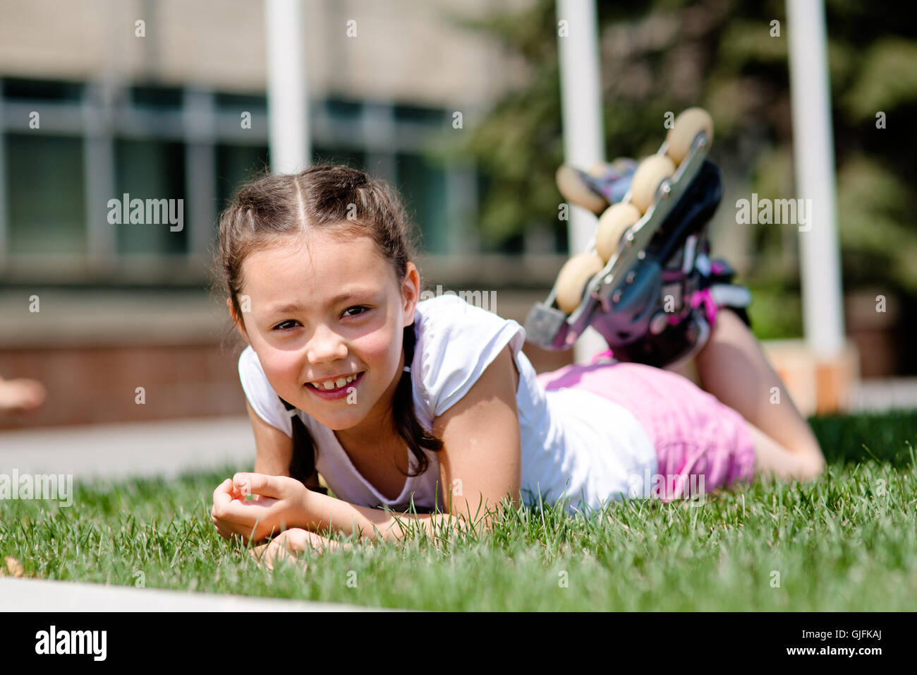 Little girl with roller skates at park laying on grass Stock Photo - Alamy