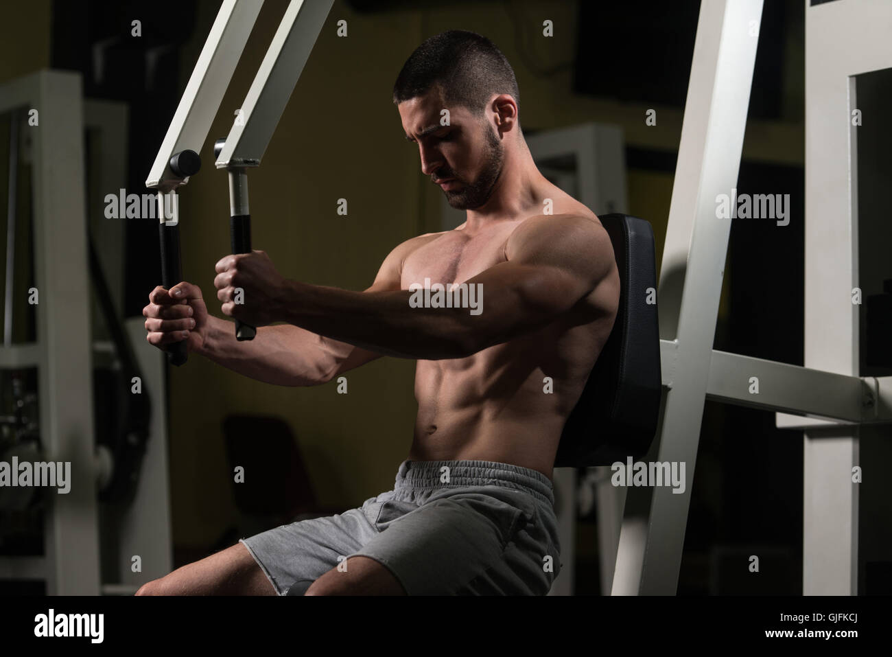 Young Bodybuilder Doing Heavy Weight Exercise For Chest On Machine ...