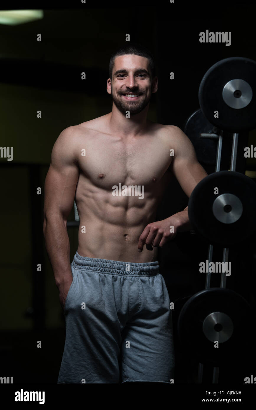 Young Man Standing Strong In The Gym And Flexing Muscles - Muscular ...