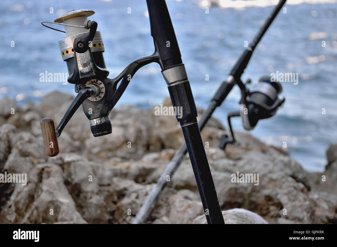 Fishing rods on the rock against sea background. Outdoor sport/gear ...