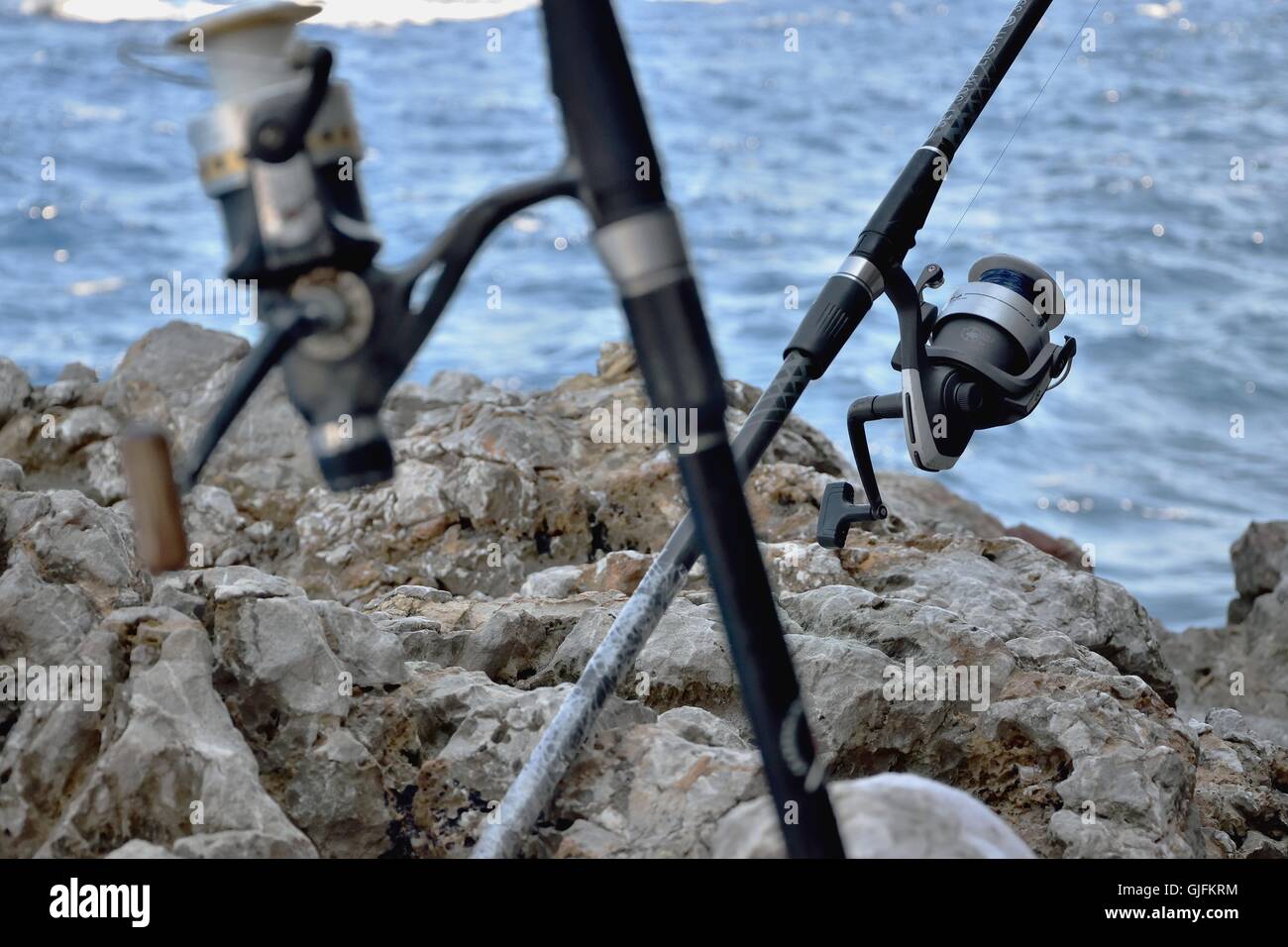 Fishing rods on the rock against sea background. Outdoor sport/gear ...