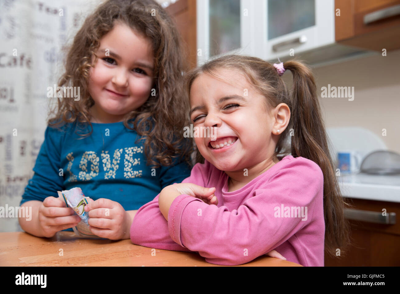 Two cute kids smiling and making faces at camera in kitchen Stock Photo ...